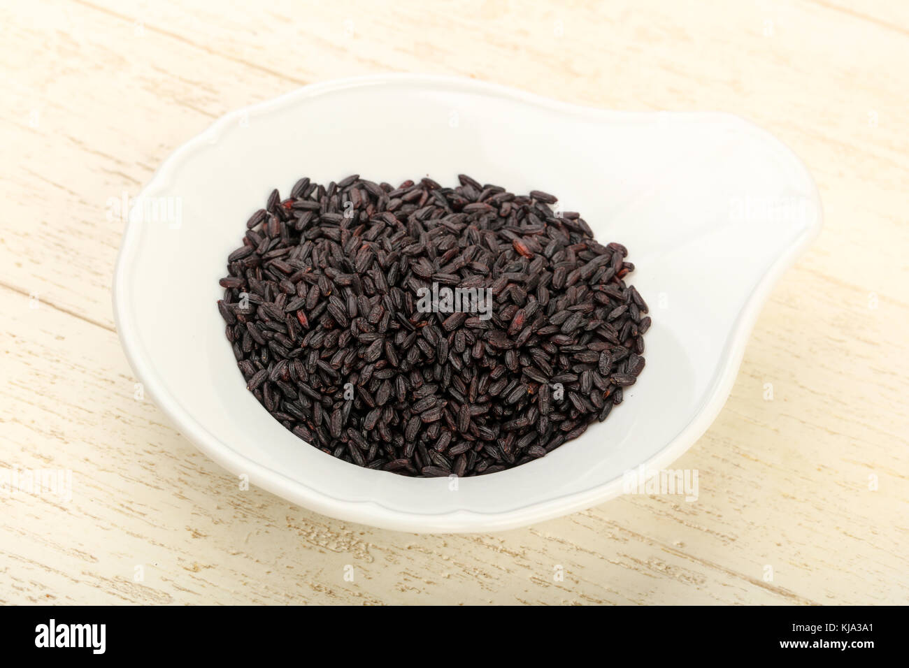 Black wild rice in the bowl over wooden background Stock Photo - Alamy