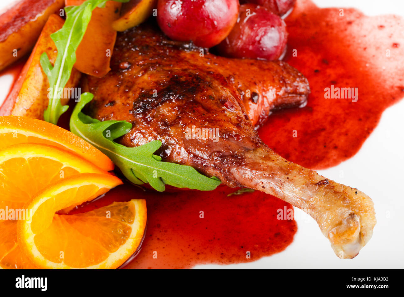 Duck leg with grape, orange and pear Stock Photo - Alamy