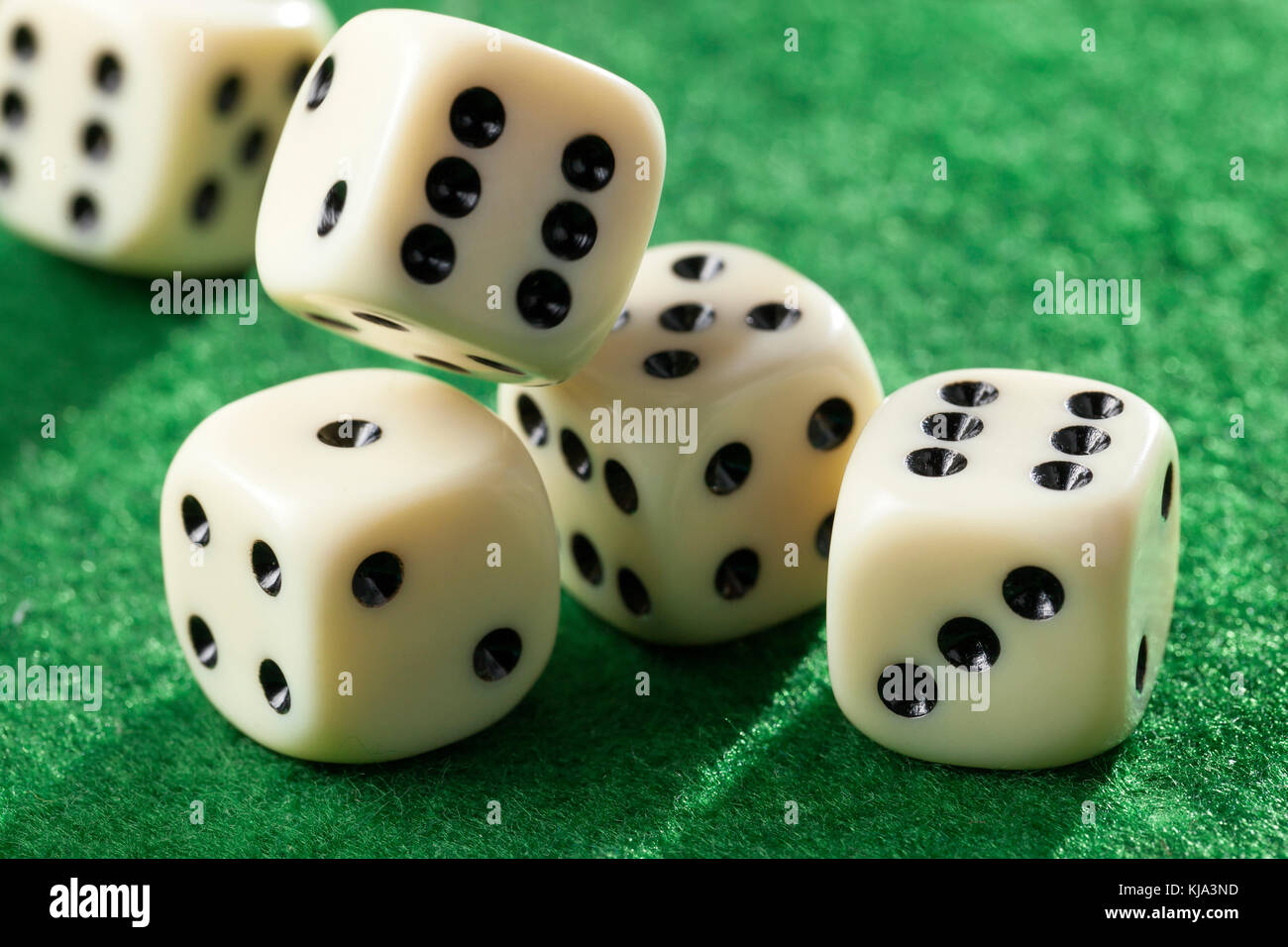 Five rolling dices in motion on green felt Stock Photo - Alamy