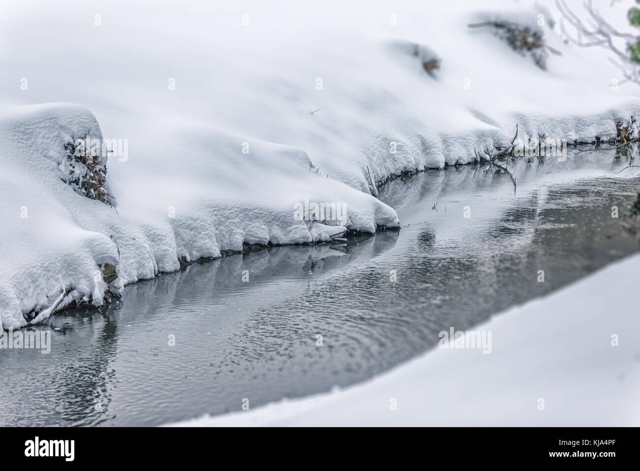 Small stream in snow Stock Photo - Alamy