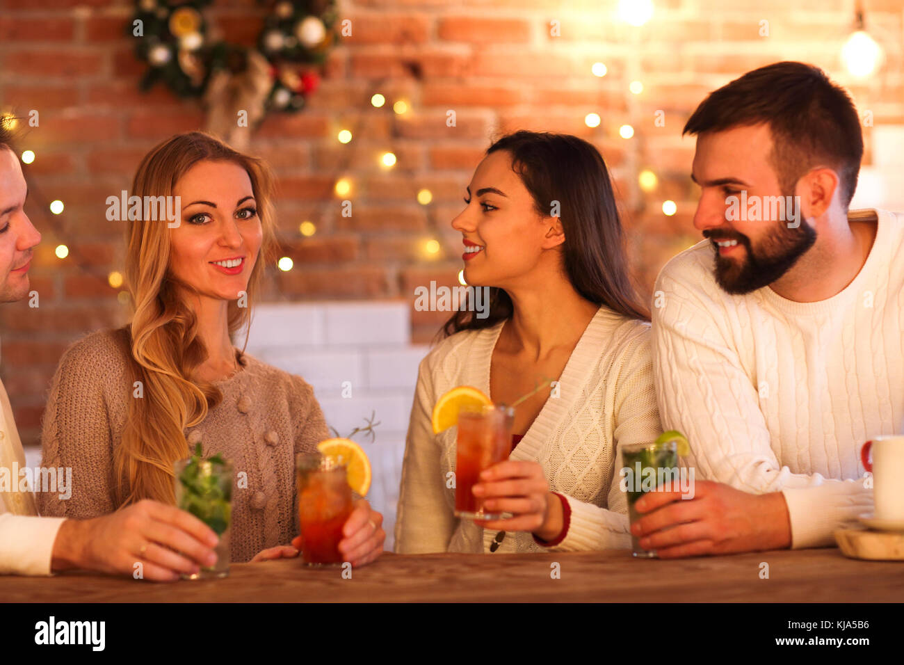 Young men and women drinking cocktail at party Stock Photo - Alamy
