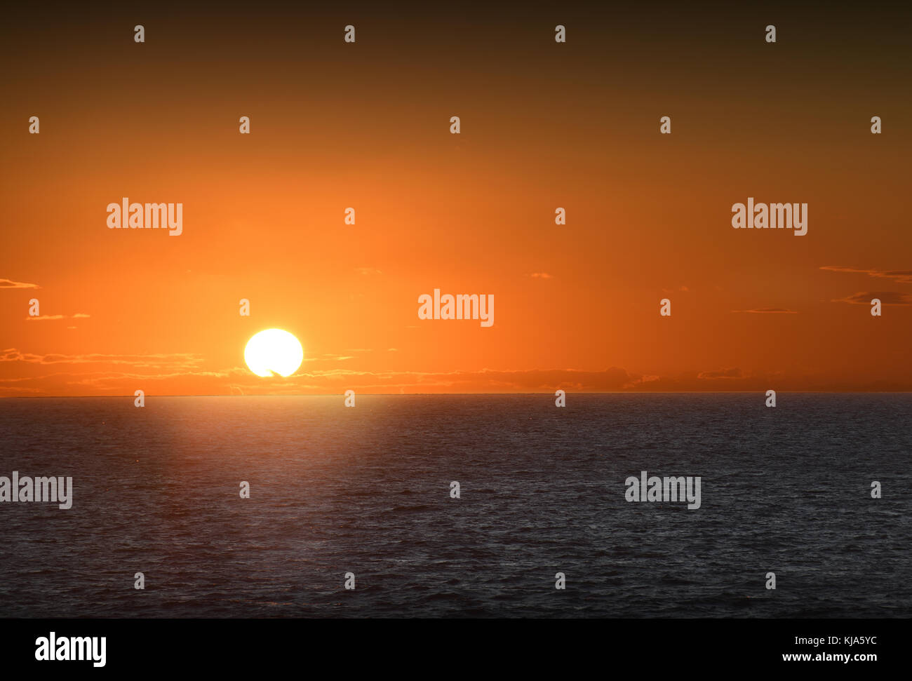 Sun setting over the sea, dramatic light using filters Stock Photo - Alamy