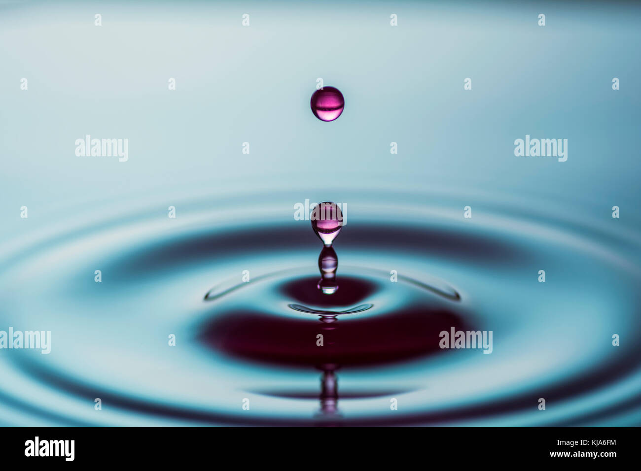 Water drop falling on water surface Stock Photo - Alamy