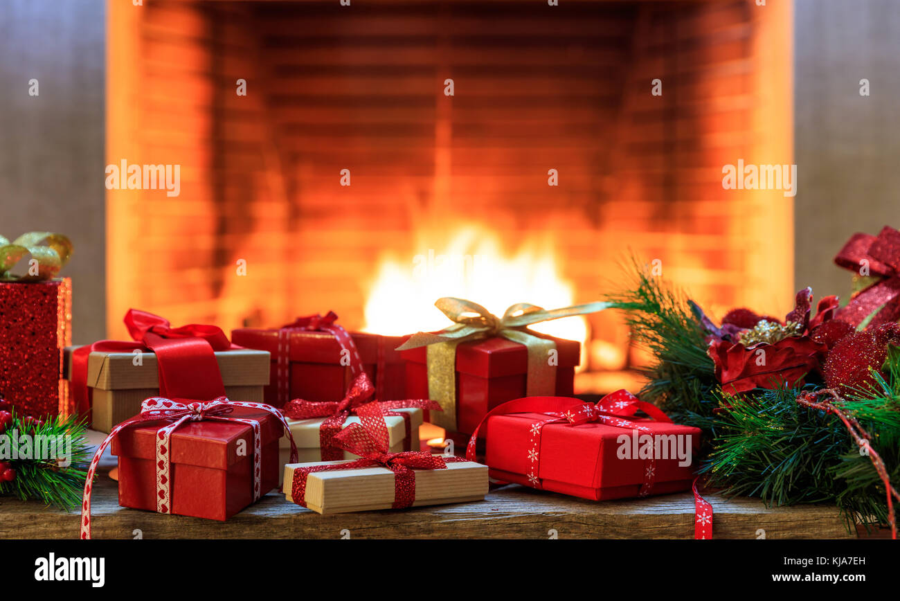 Christmas gift boxes close up on blurred burning fireplace background ...