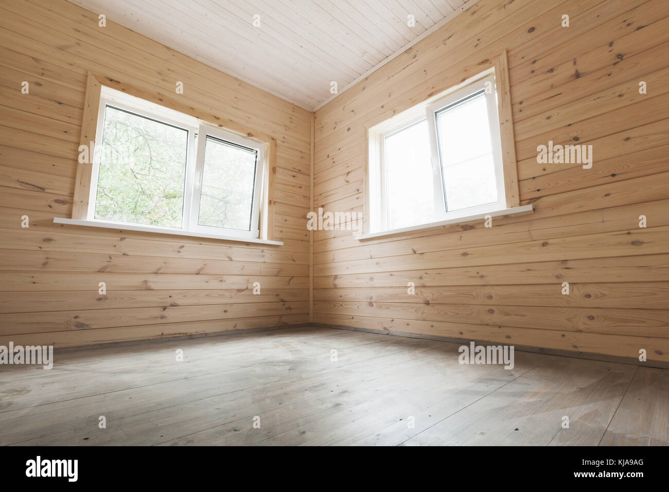 Empty new room interior, wooden walls and two bright windows near ...