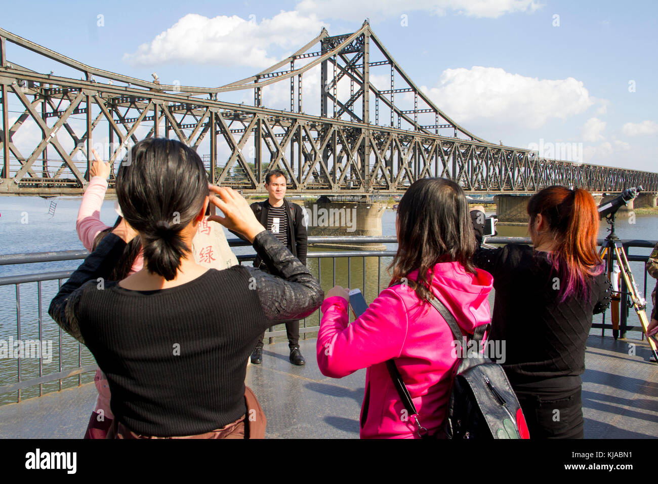 Tourists take photos on the Broken Bridge on the Yalu river in Dandong ...