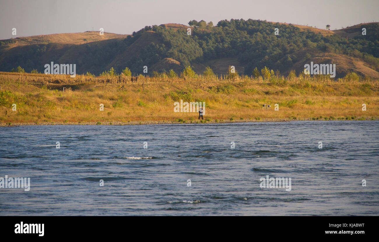 A North Korean walks next to the Yalu river inside North Korea Stock ...