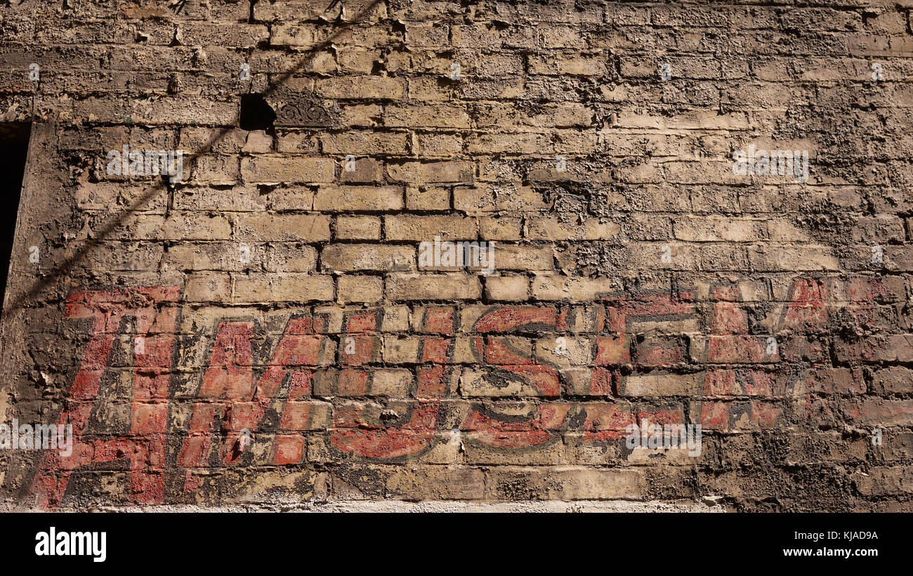 Brick work and old fashioned writing on a weathered wall Stock Photo ...