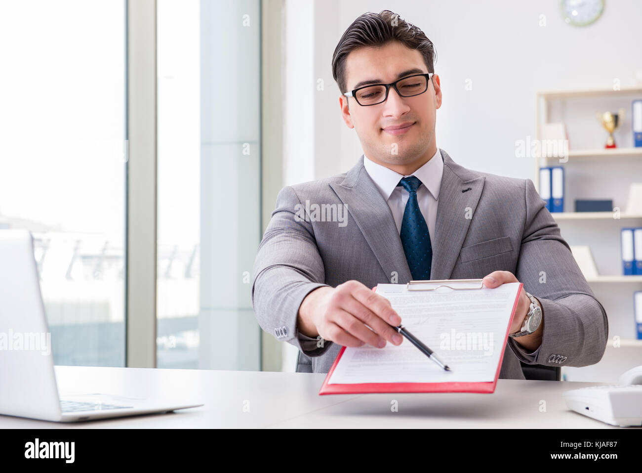 Businessman signing business documents in office Stock Photo - Alamy
