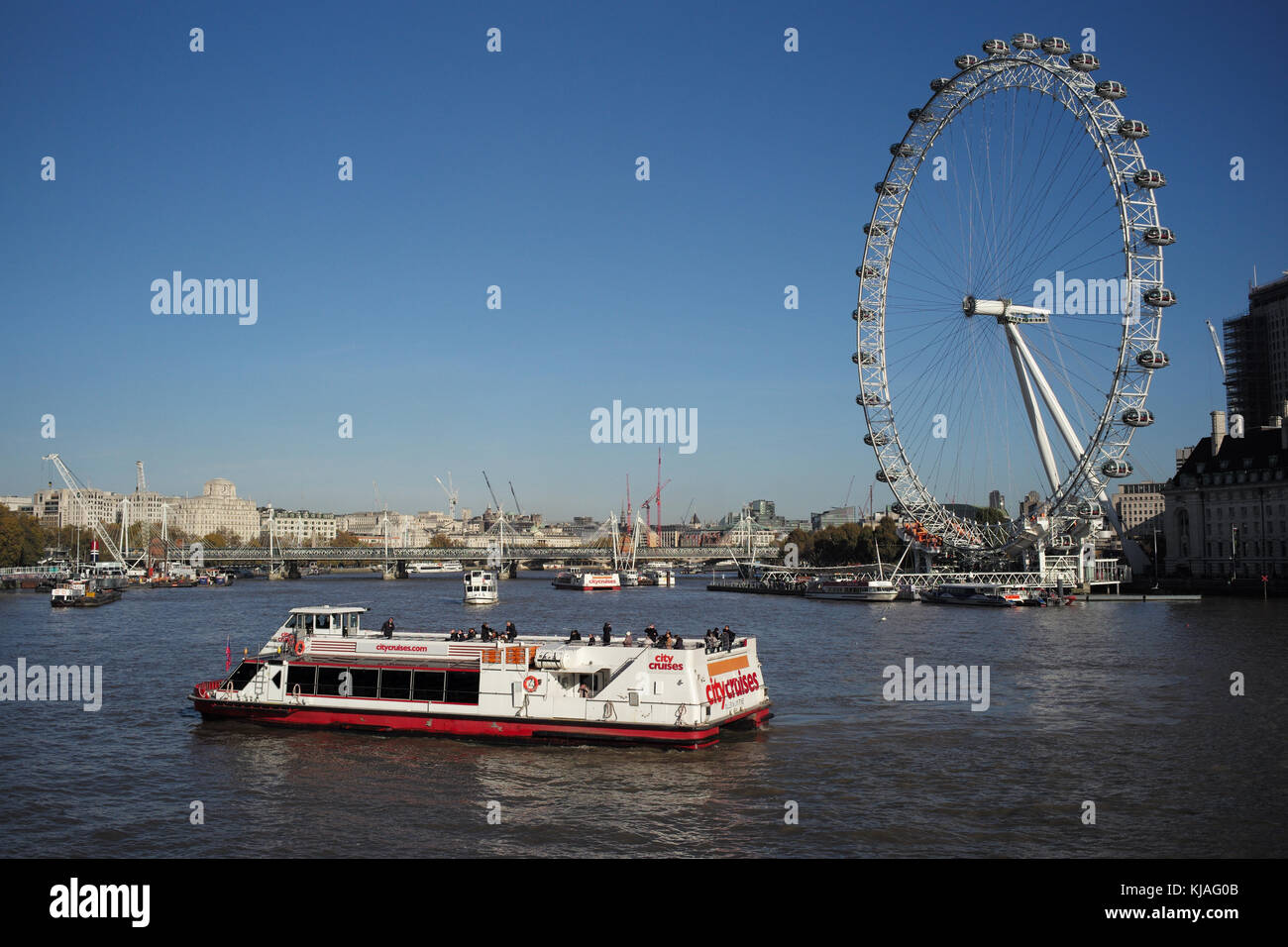 City cruises vessel sits in front of the London eye on the River Thames ...