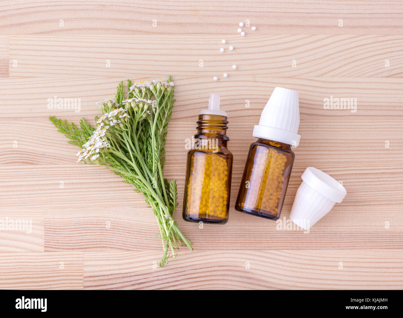 Top view of Homeopathic remedy with flowering yarrow with a wooden ...