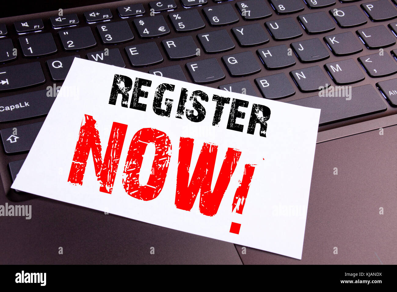 Writing Register Now text made in the office close-up on laptop ...