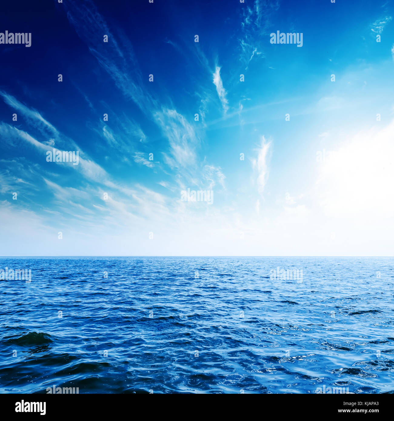 sunset in deep blue sky with clouds over sea Stock Photo - Alamy