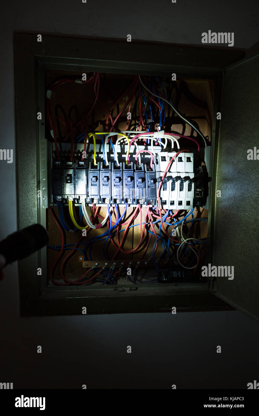 LED flashlight torch lamp illuminating part of old circuit breaker ...