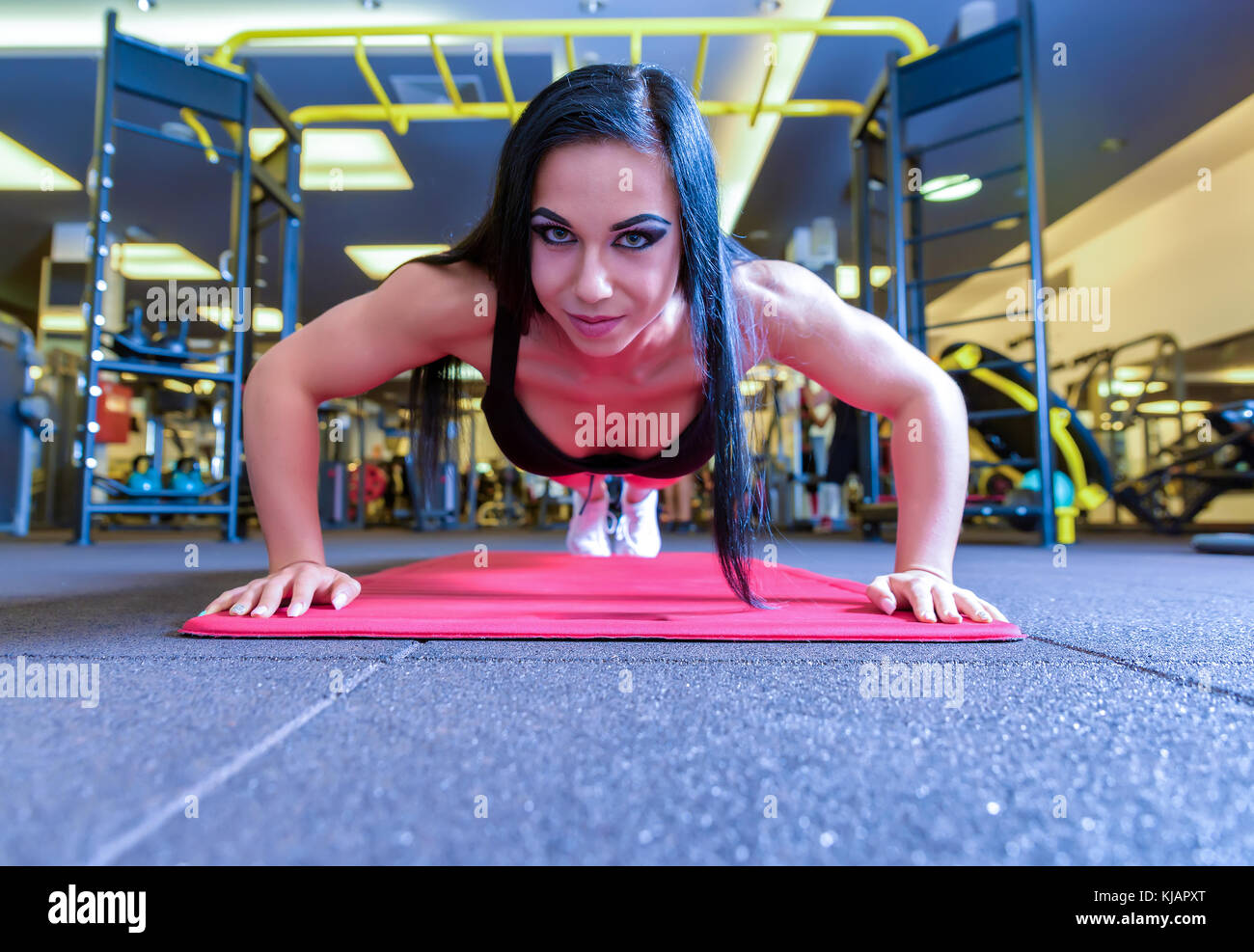 A beautiful young girl working on her arm muscles by performing push ...