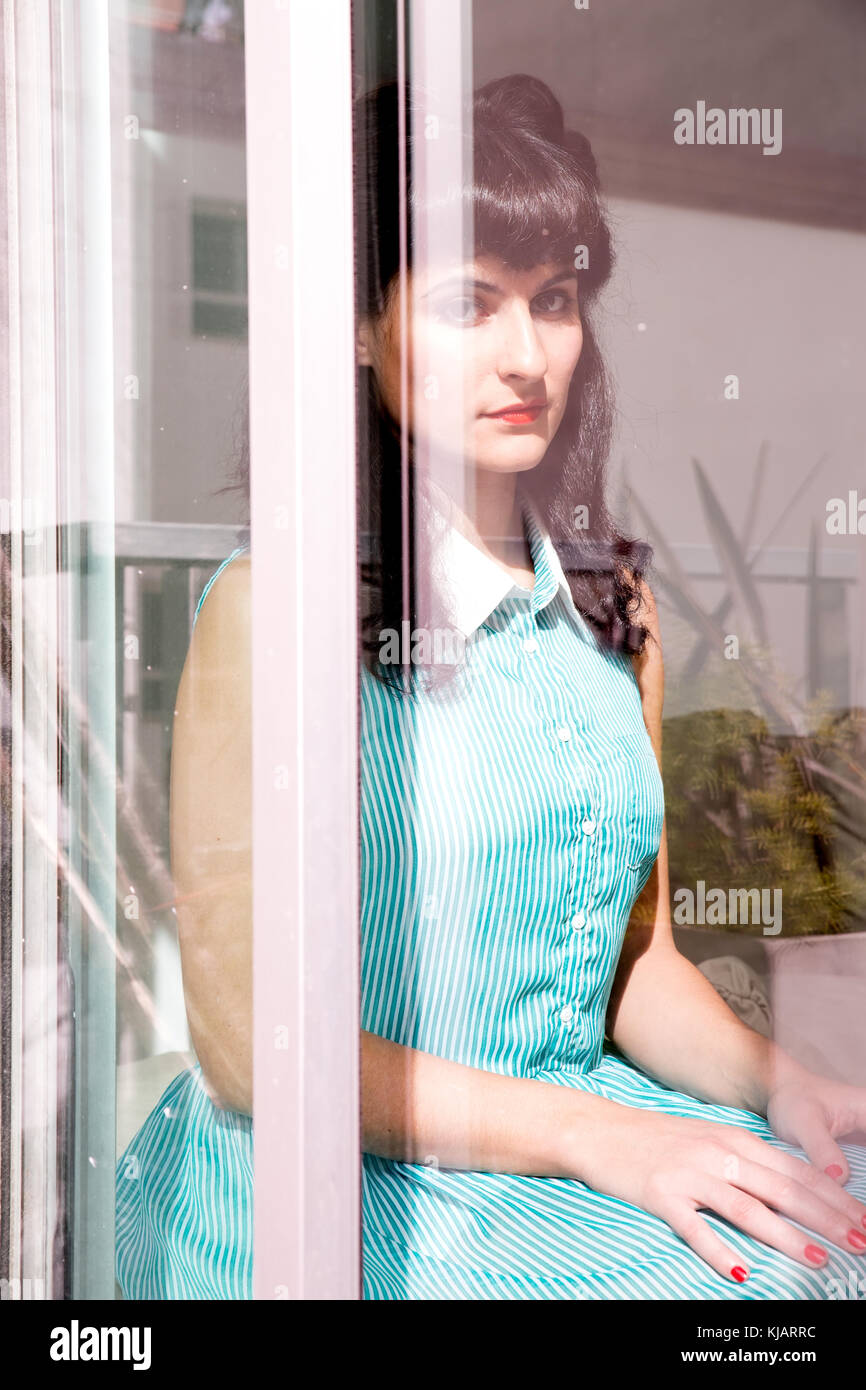 A vintage styled woman sitting beside the window Stock Photo - Alamy