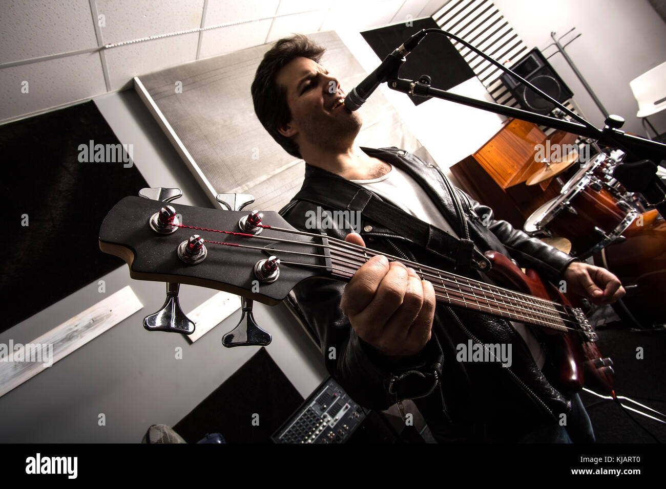 A Rock musician playing passionately bass in the rehearsal Studio Stock ...