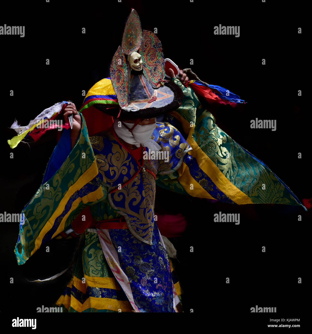 Buddhist lama in a large sacral hat with a human skull and bright ...