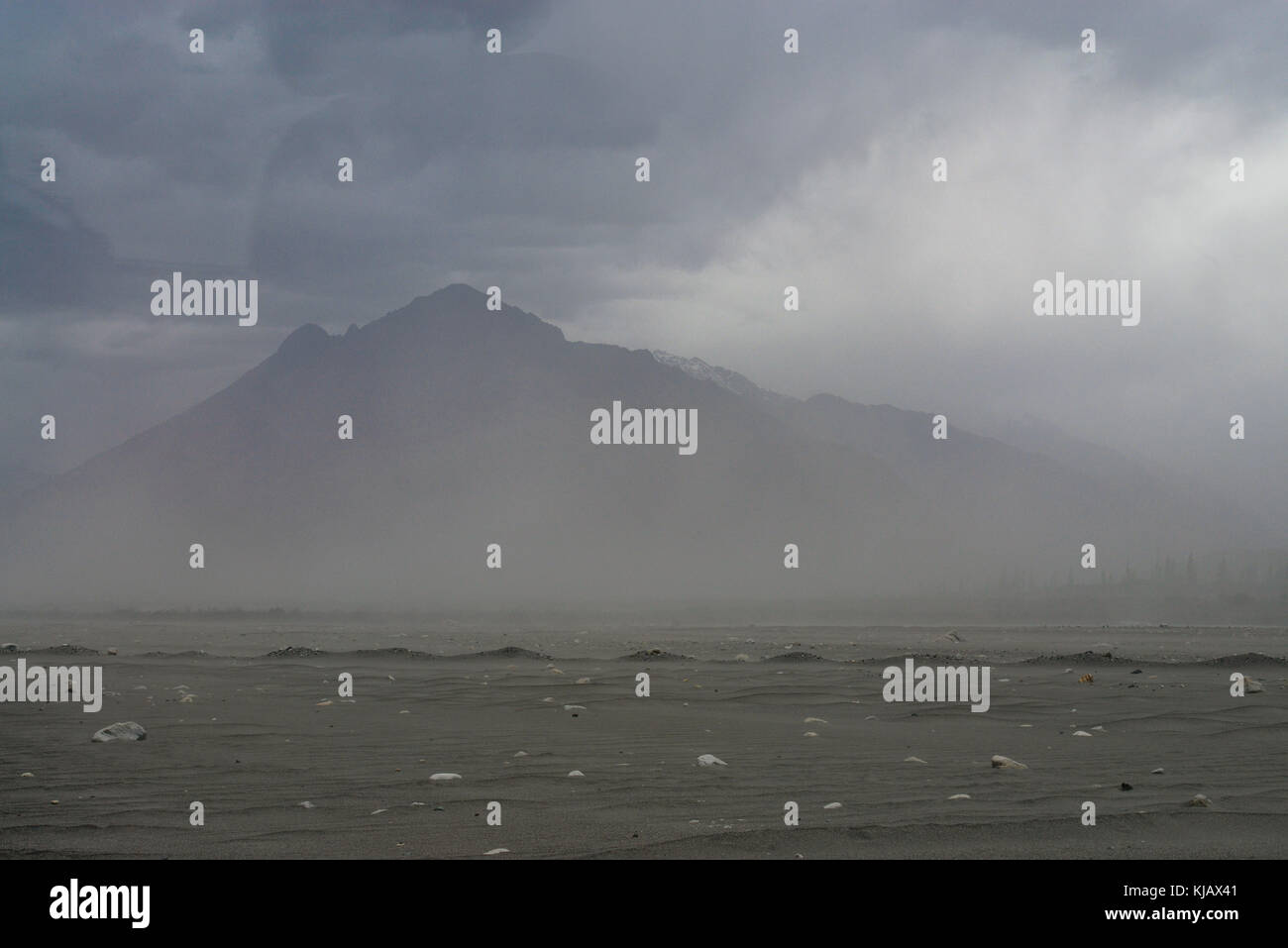 Dust storm in the mountains: a sandy desert, the wind raises sand in ...
