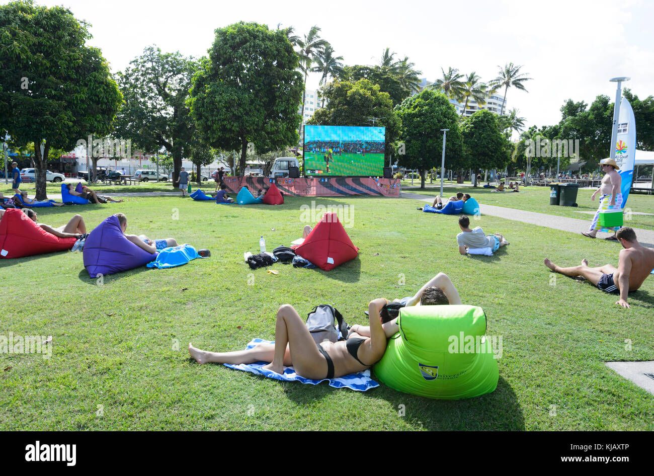 People leisurely watching a rugby match on a giant TV screen from their ...