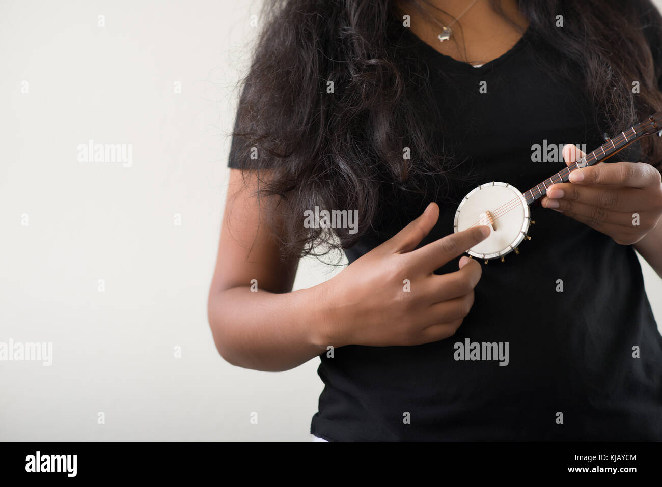 Young Lady Playing A Tiny Instrument Stock Photo - Alamy