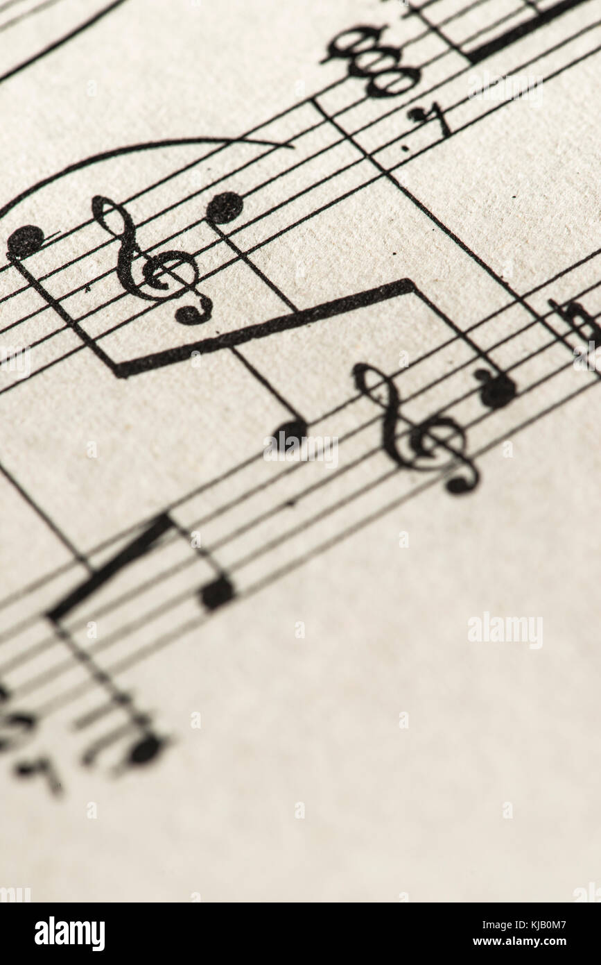 Treble clef and music notes on vintage paper pages Stock Photo - Alamy