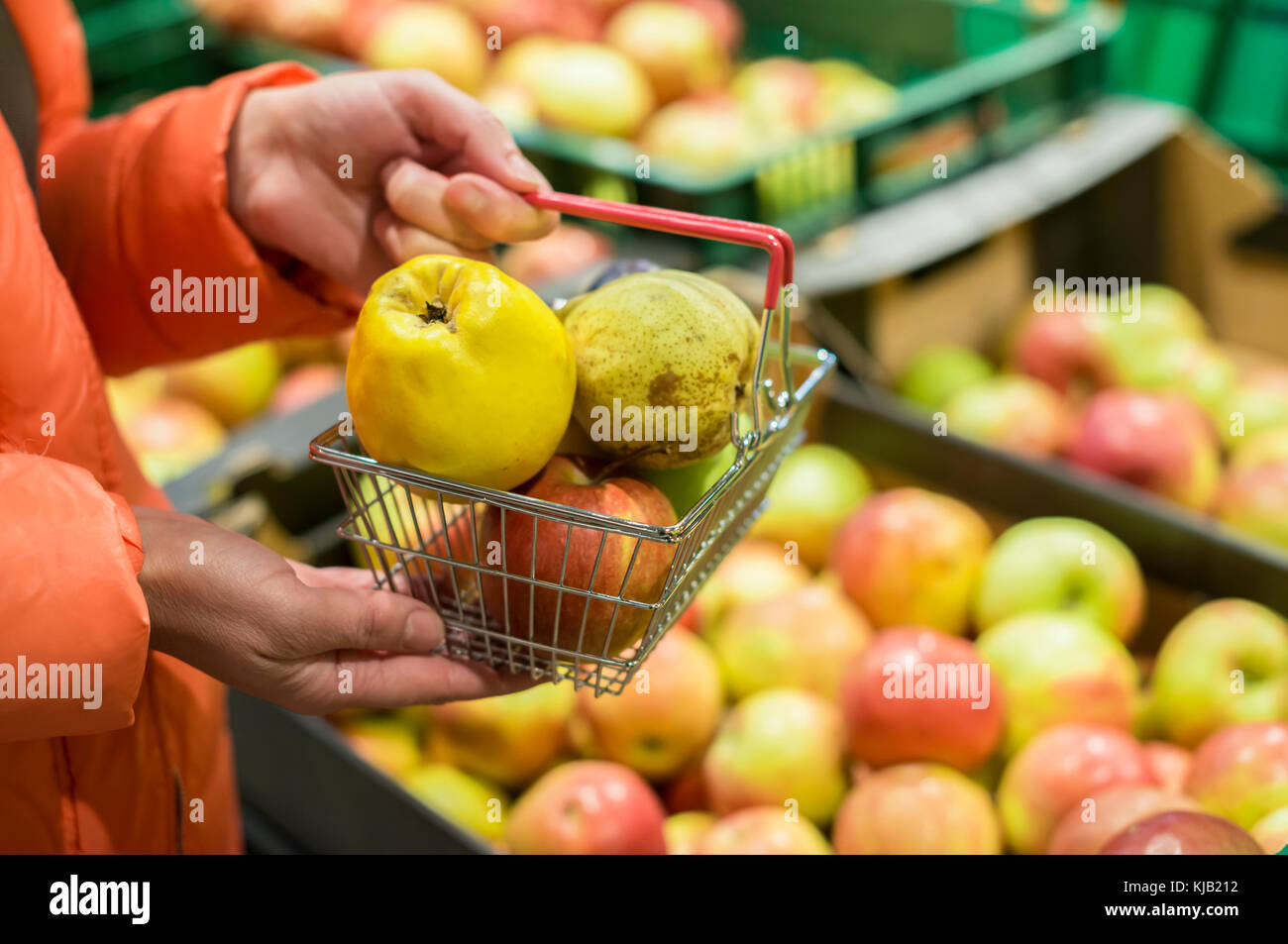 Fruits in supermarket. Buying apples and pears in shop. Small basket ...