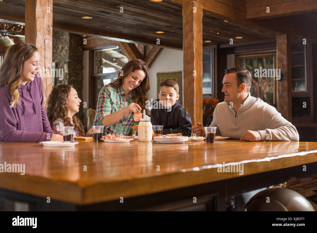 Smiling Caucasian family eating meal at table Stock Photo - Alamy