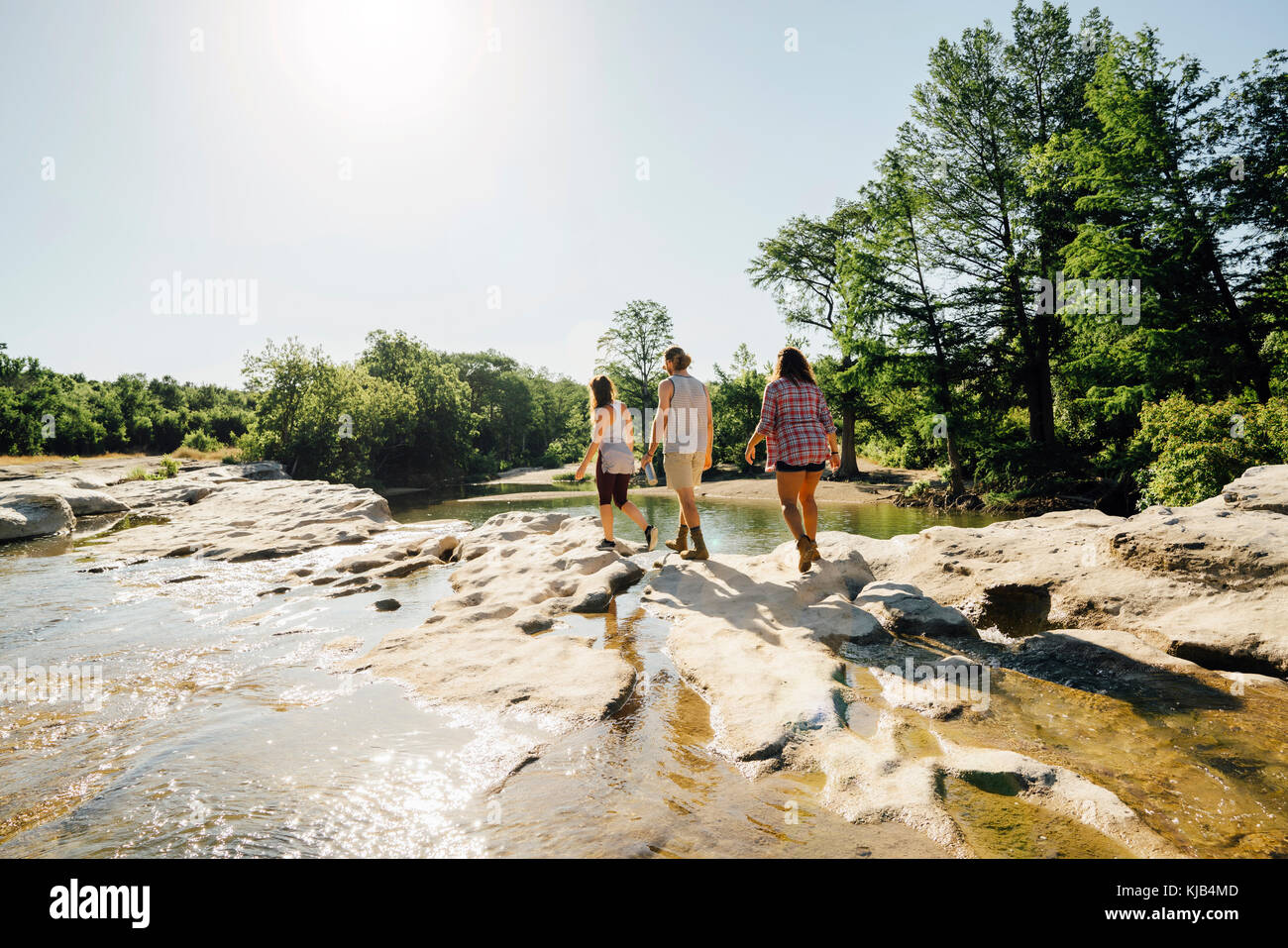 Friends walking on rocks near river Stock Photo - Alamy