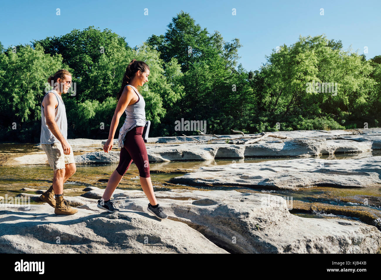 Caucasian couple walking on rocks near river Stock Photo - Alamy