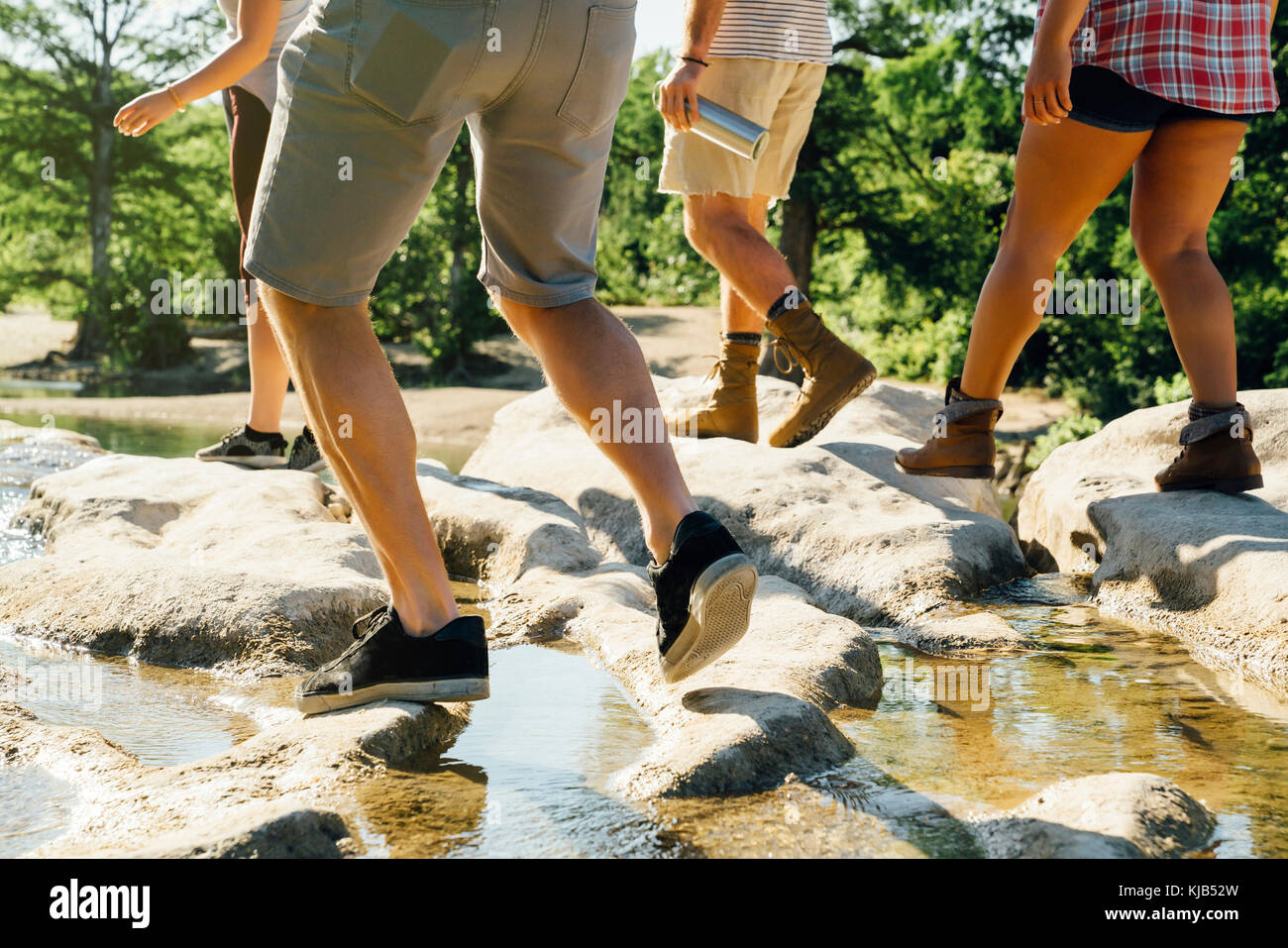 Friends walking on rocks near river Stock Photo - Alamy