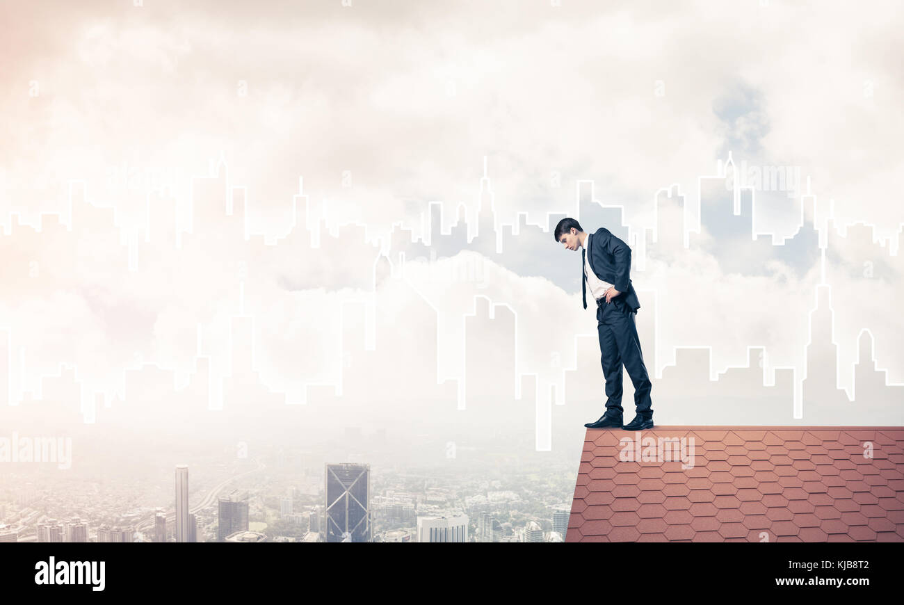 Businessman looking down from roof and modern cityscape at backg Stock ...