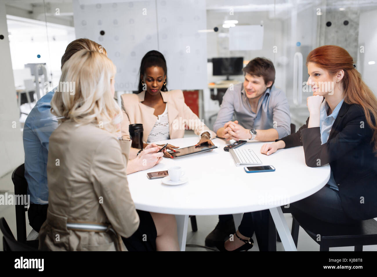 Group of business people sitting at desk Stock Photo - Alamy