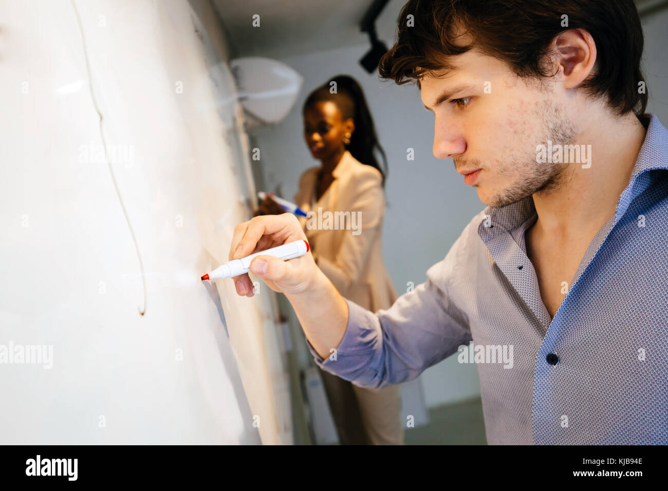 Smart people writing on whiteboard Stock Photo - Alamy