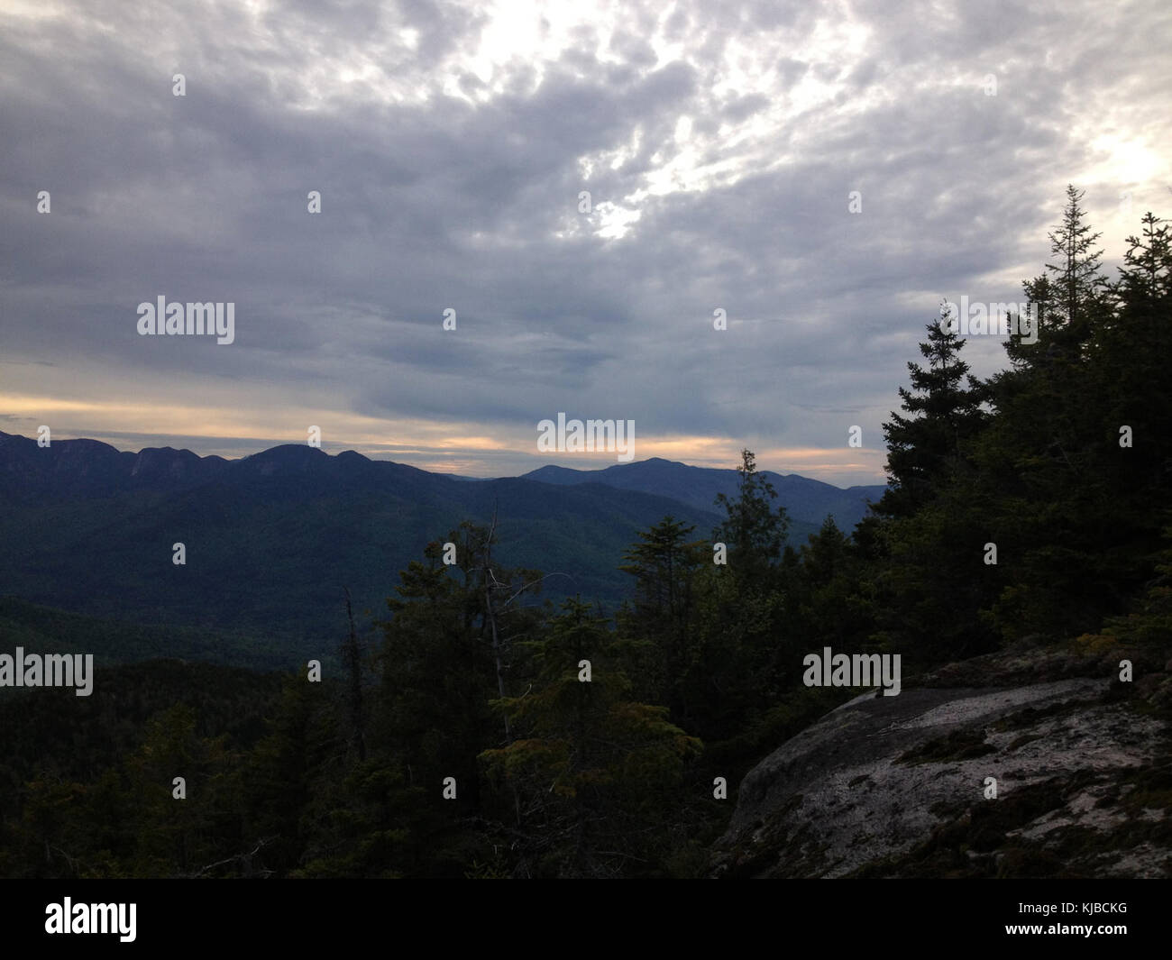 The image captures the stunning sunset over the Adirondack Mountains in ...