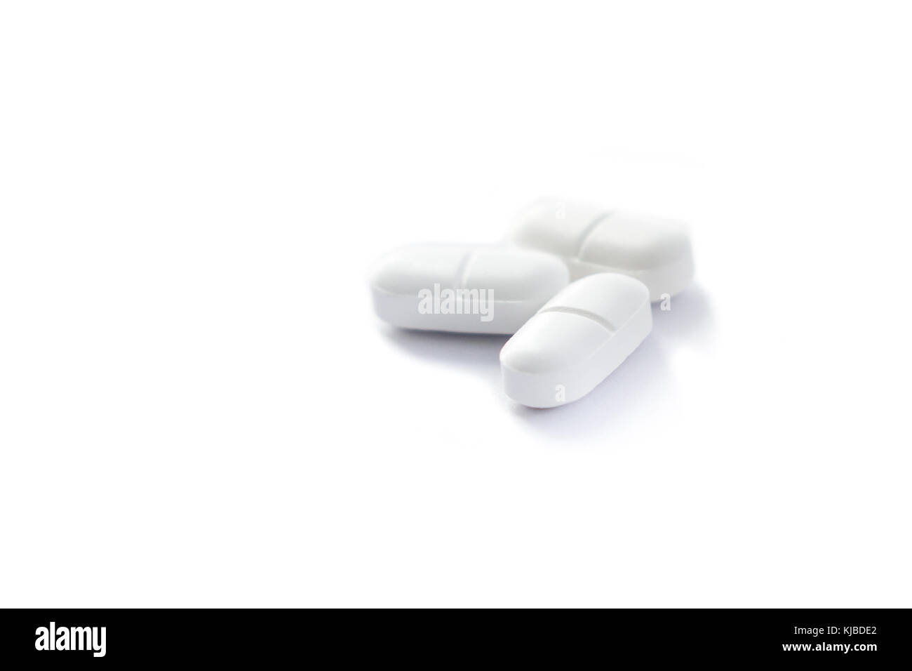 close up of a group of white tablets isolated on a white background ...