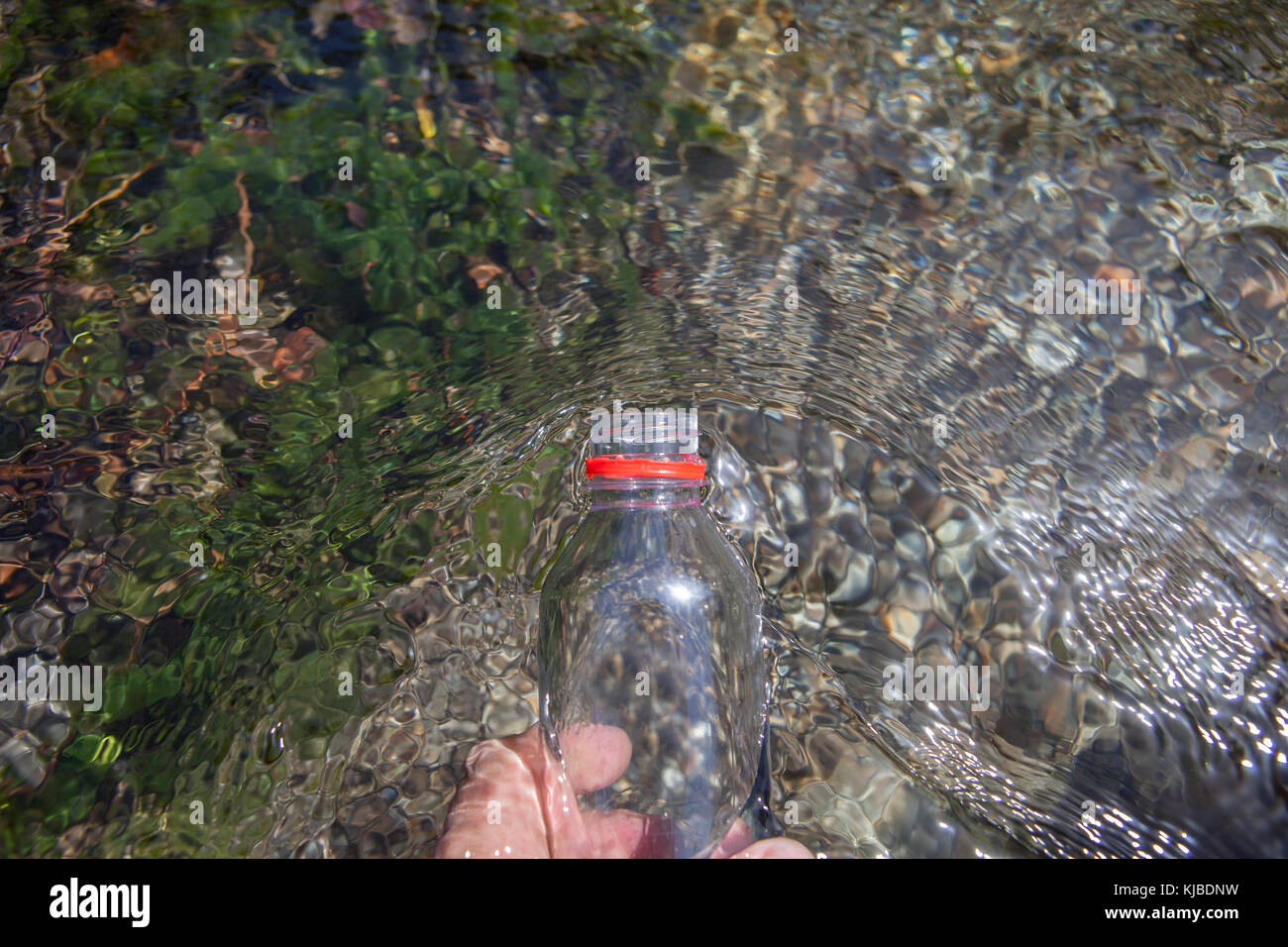 Trekker filling with fresh mountain water from ancient acequia ...
