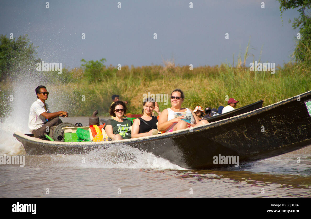 Tourists ride on motorboats across Inle Lake in Myanmar. Inle lake is a ...
