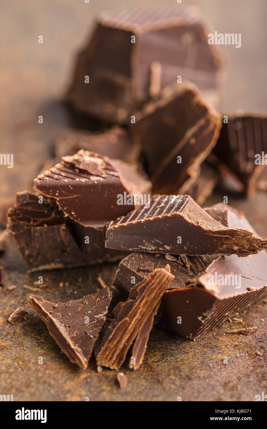 Chopped dark chocolate on rusty background Stock Photo - Alamy