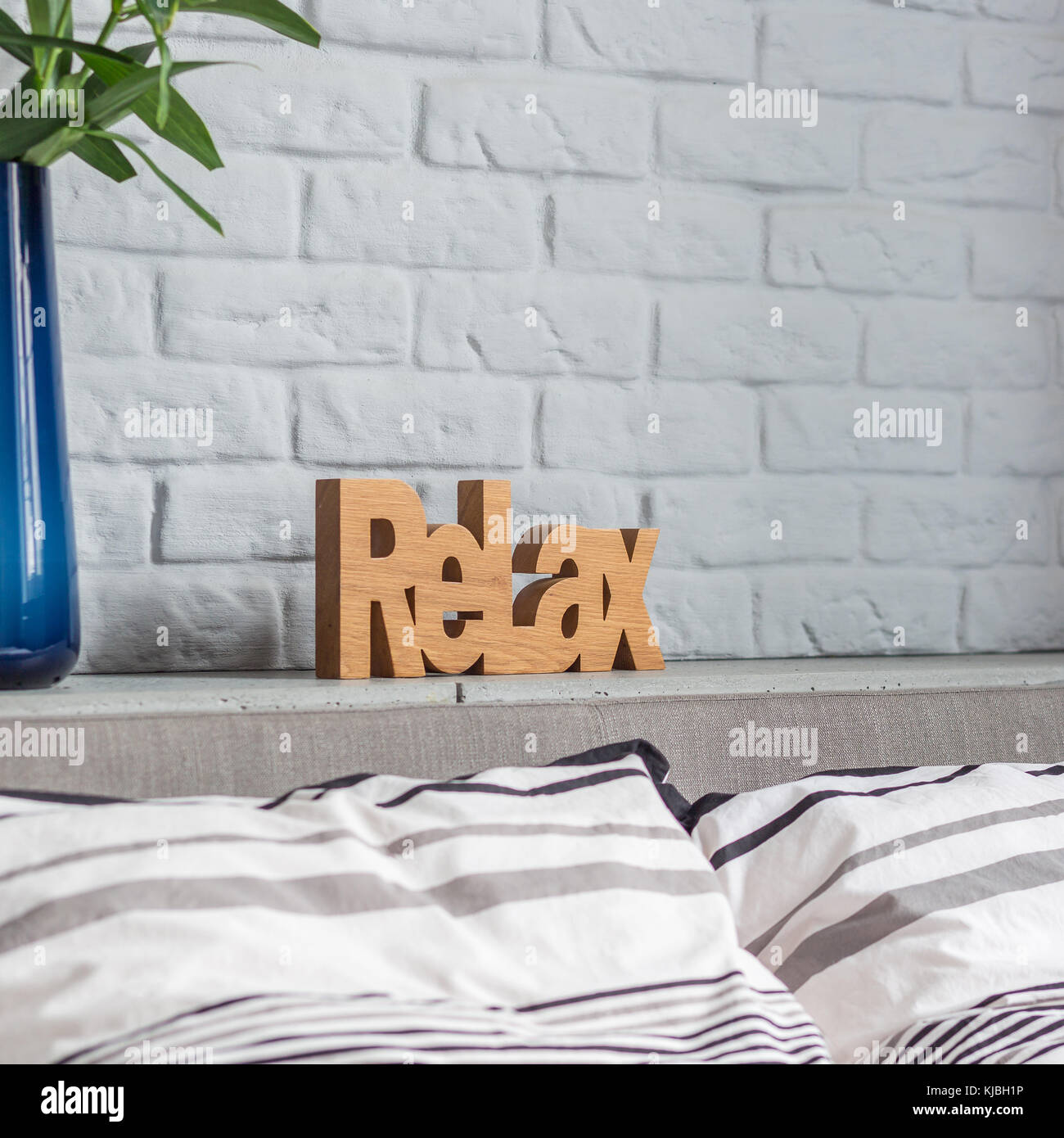 Decorative relax sign in new bedroom with double bed and brick wall ...