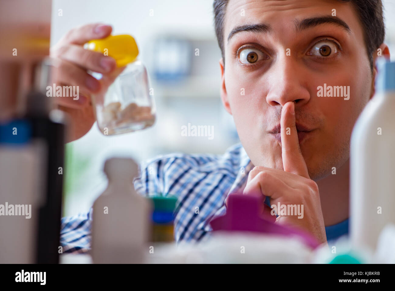 Sick ill man looking for medicines at farmacy shelf Stock Photo - Alamy