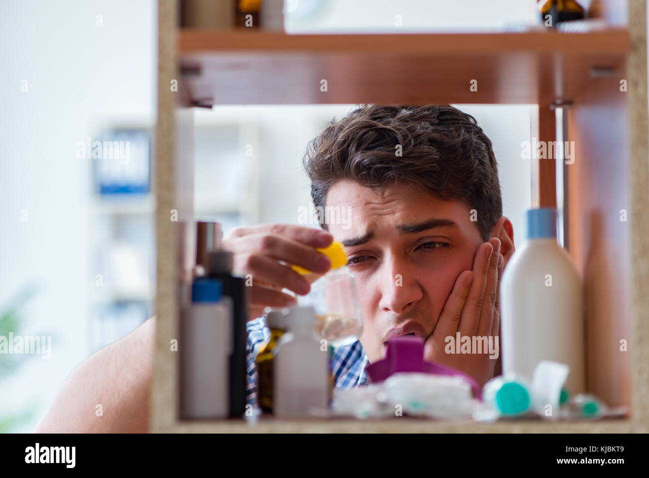 Sick ill man looking for medicines at farmacy shelf Stock Photo - Alamy