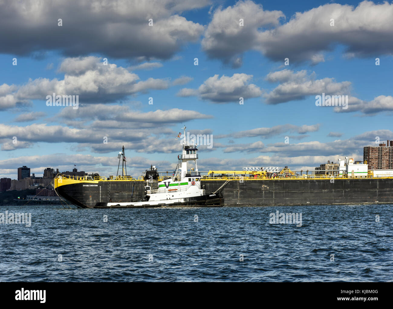 Tug boat serving a container ship in the Hudson River off of Manhattan ...