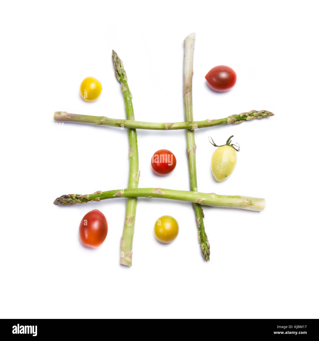concept for healthy food games using asparagus and tomatoes to play tic ...