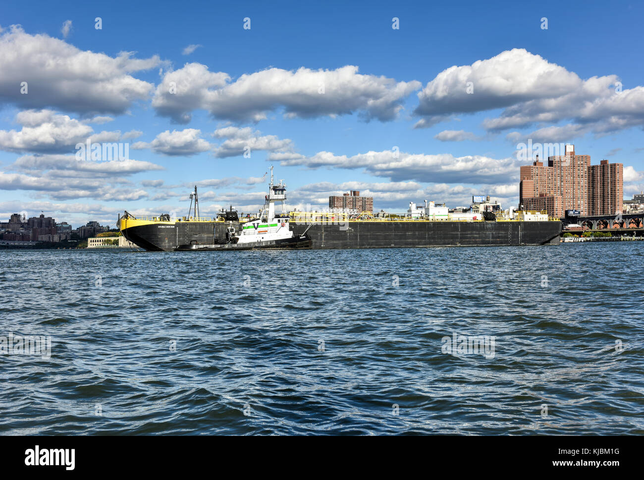 Tug boat serving a container ship in the Hudson River off of Manhattan ...