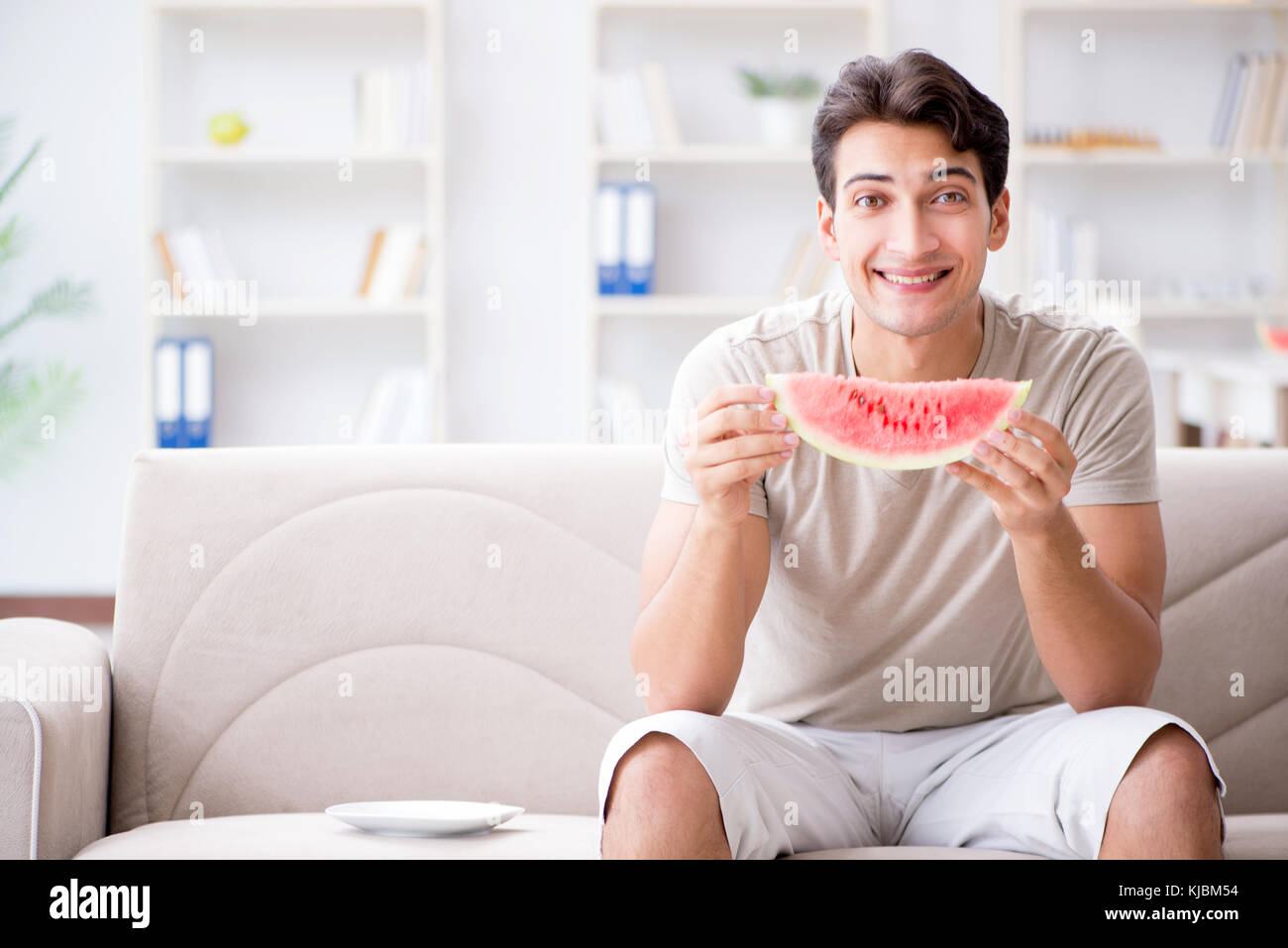 Man eating watermelon at home Stock Photo - Alamy