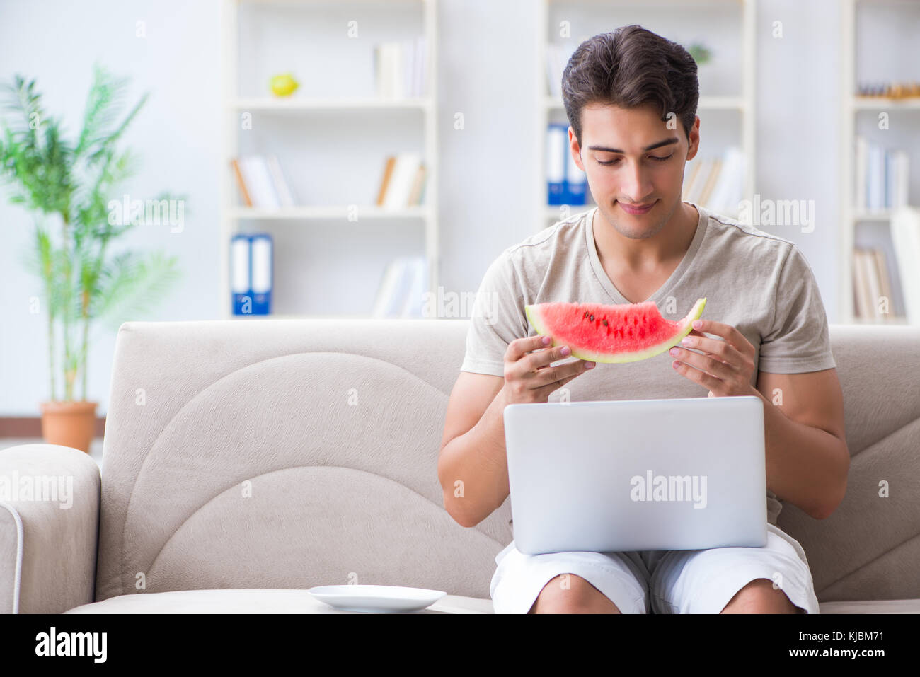Man eating watermelon at home Stock Photo - Alamy