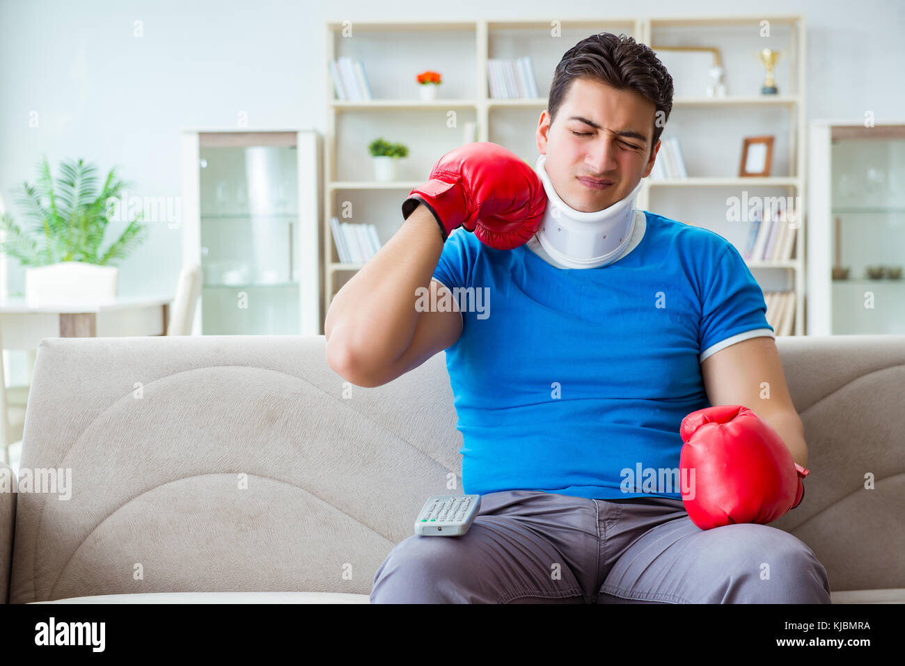Man with neck injury watching boxing at home Stock Photo - Alamy