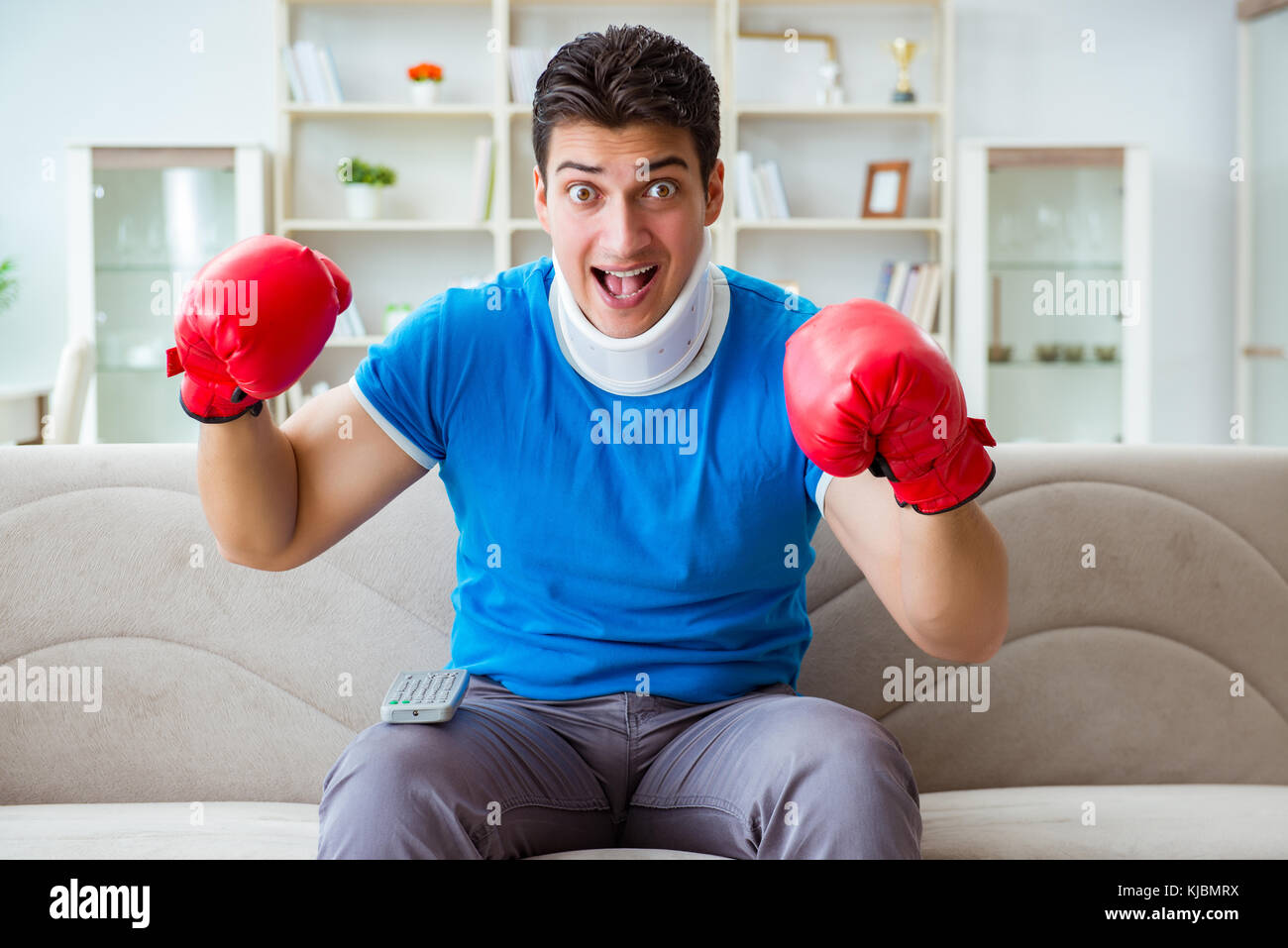 Man with neck injury watching boxing at home Stock Photo - Alamy