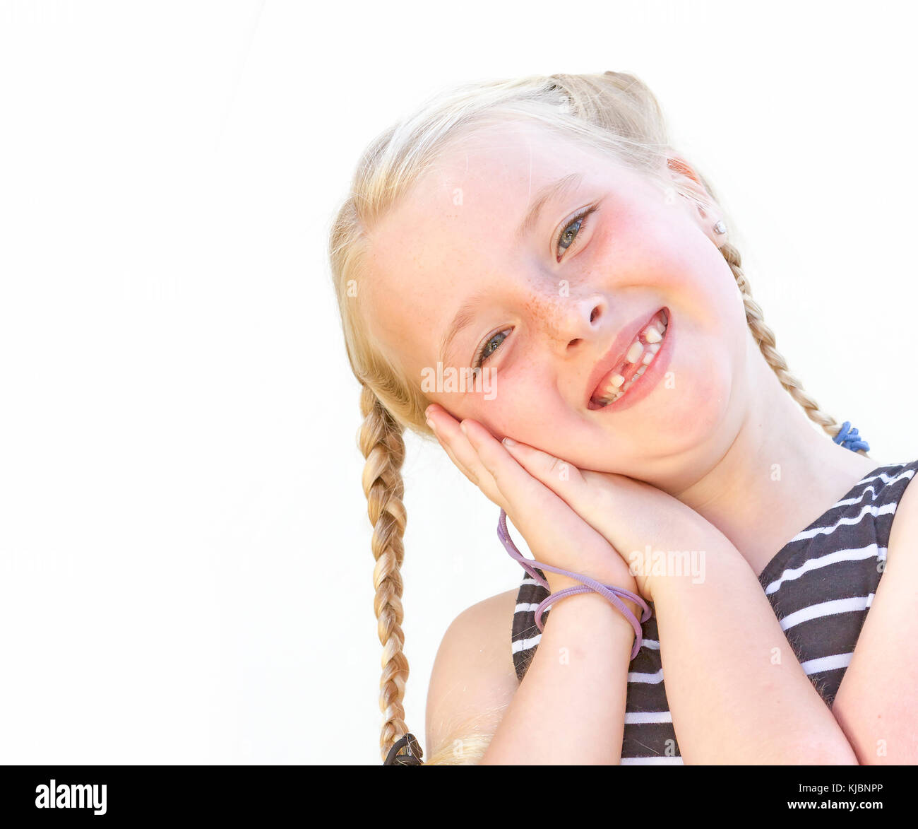 Blonde girl with plaits posing like a model in front of a white ...